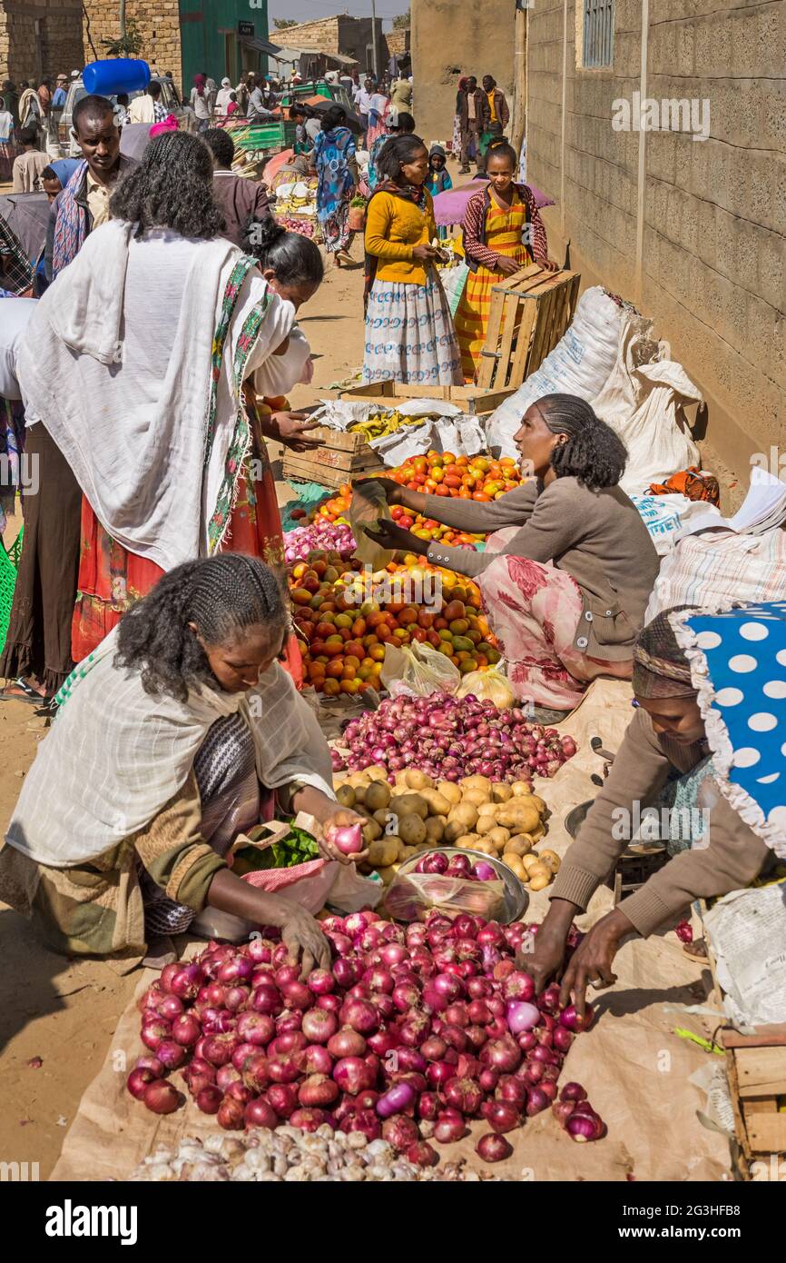 Vendors sell produce at the public market in the town of Hawzen, Tigray ...