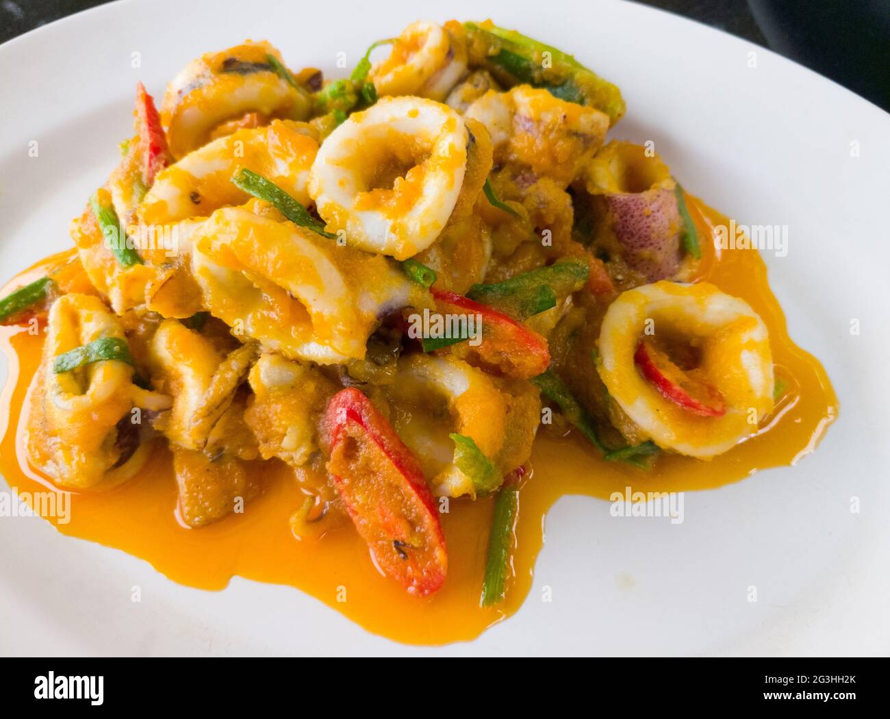 Stir-fried squid with salted eggs on the white plate for the dinner in ...