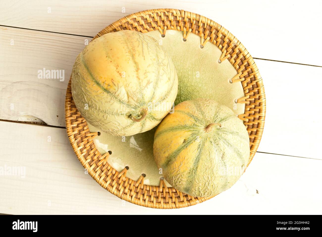 Two fragrant organic melons on a ceramic plate, close-up, on a white ...