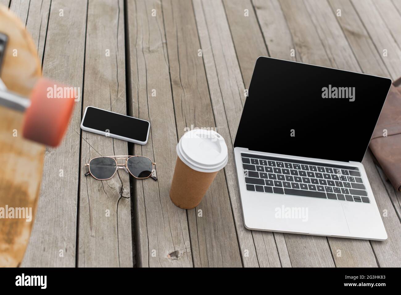 gadgets with blank screen, sunglasses and paper cup on wooden table ...