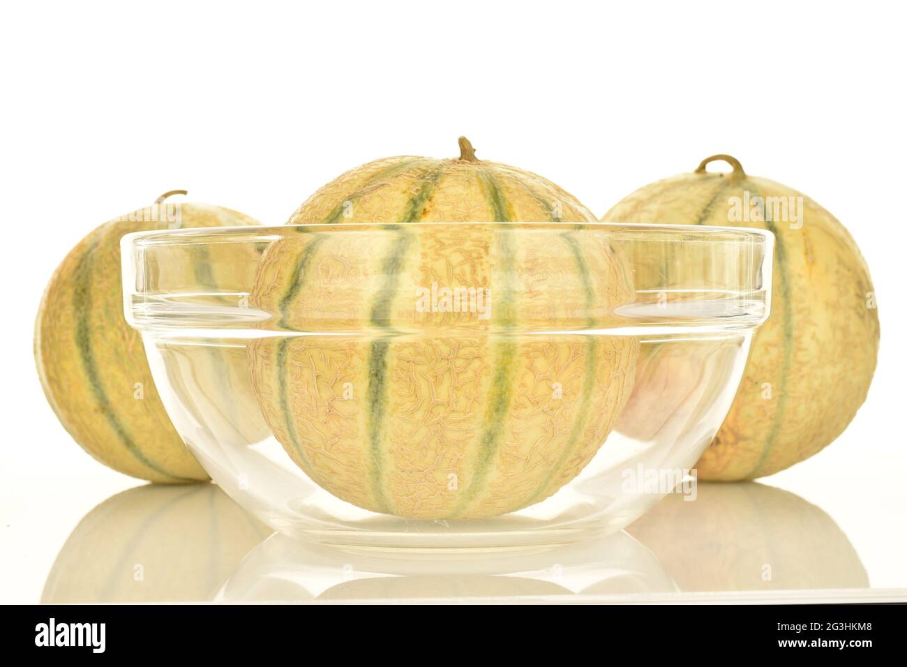 Three fragrant juicy organic melons, one in a glass bowl - in focus ...