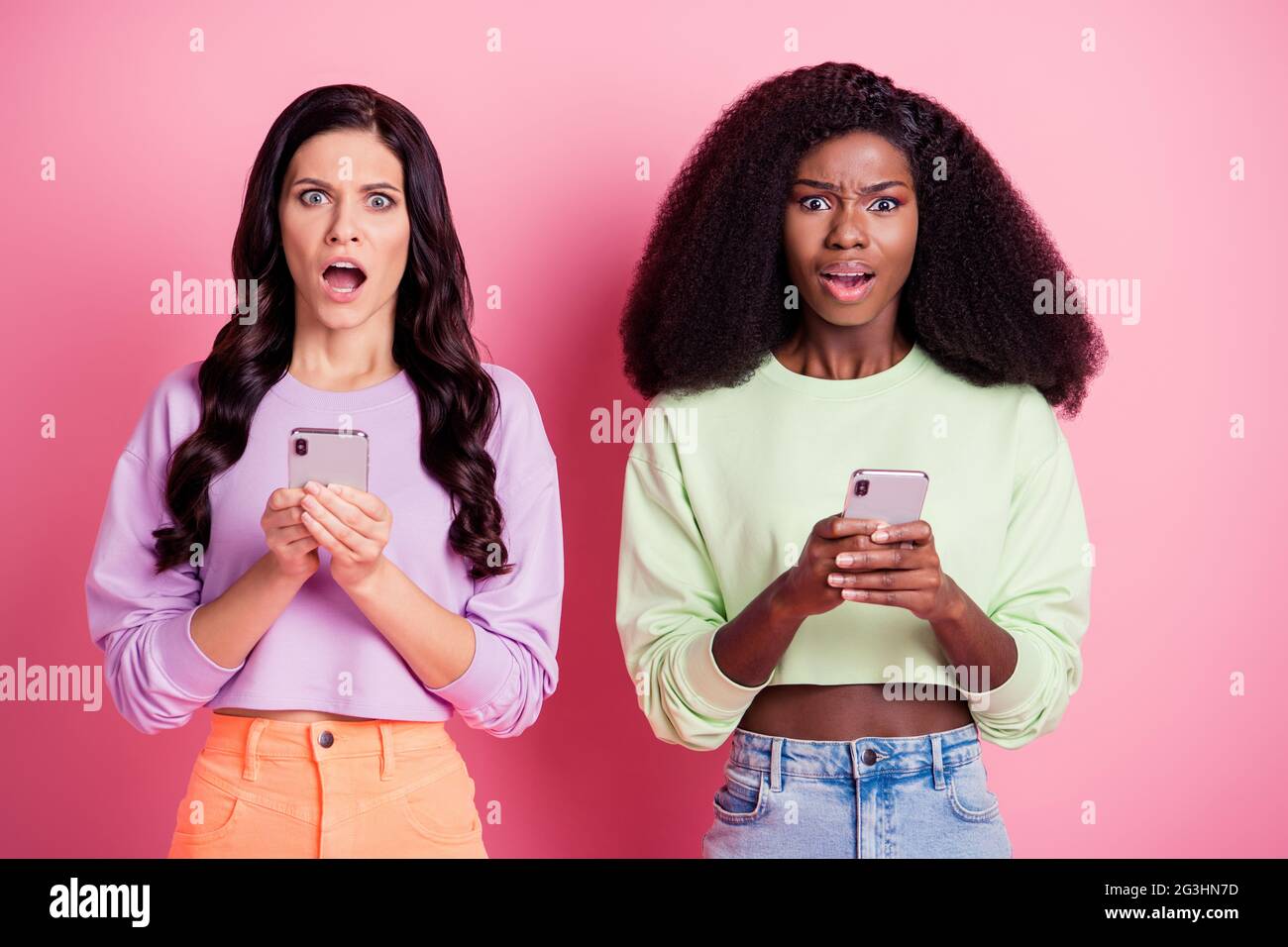 Portrait of attractive mad trendy girls friends friendship using gadget ...