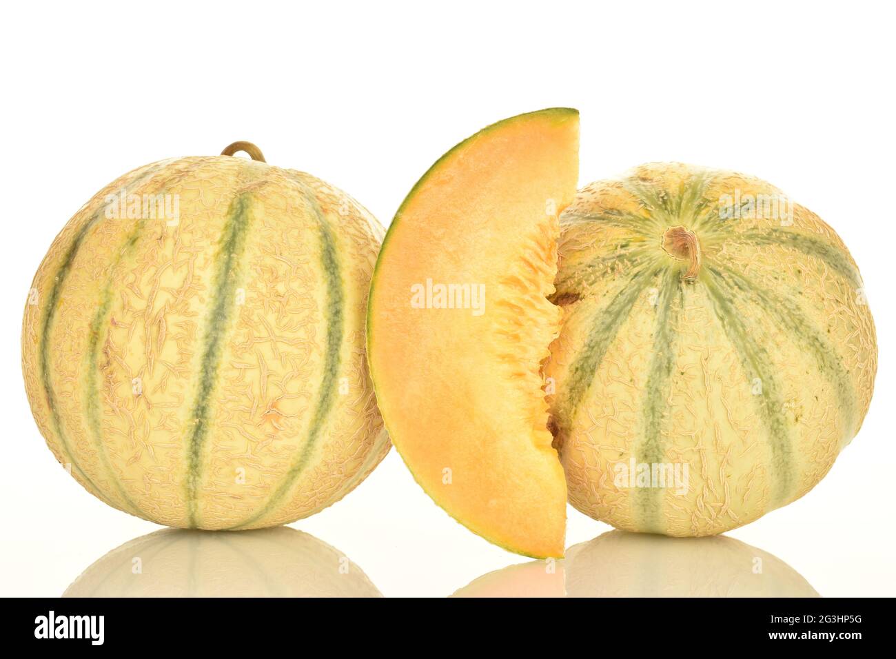 One slice in focus and two whole fragrant juicy organic melons, close ...