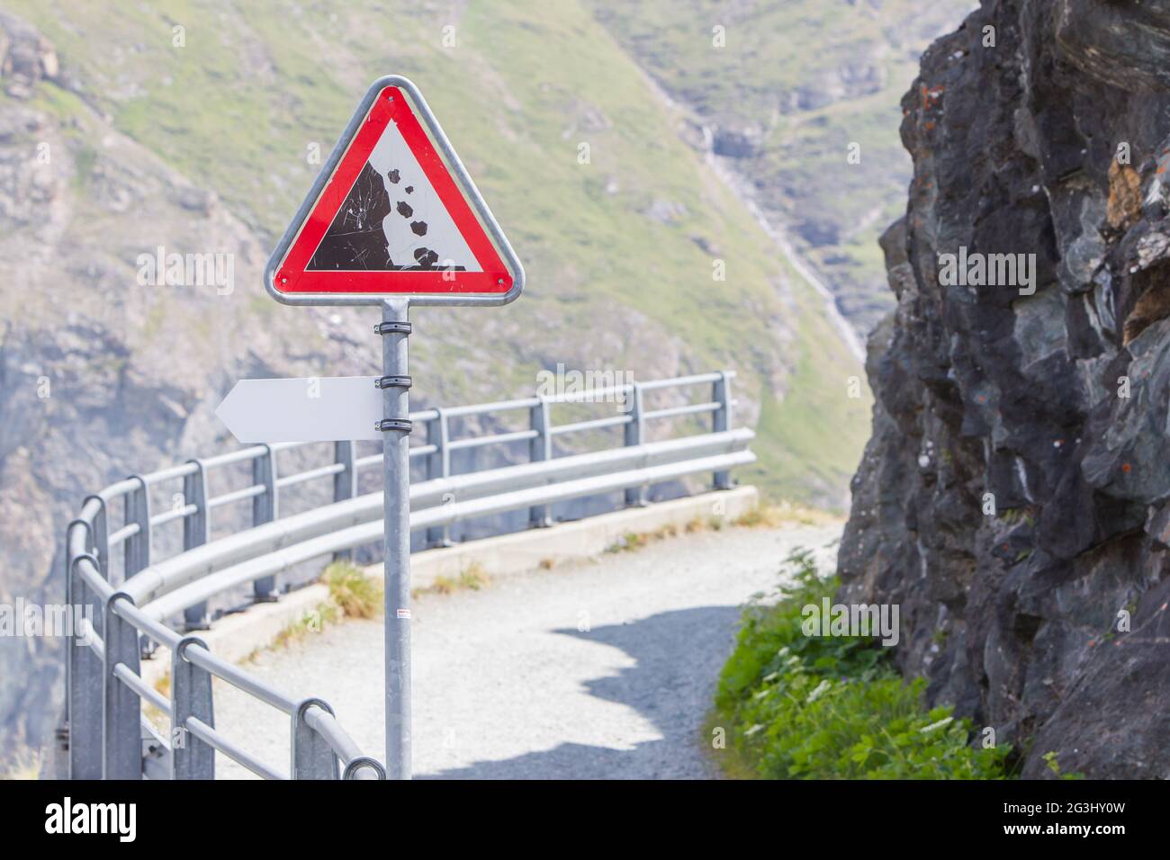 Warning stone fall road sign on mountain road Stock Photo - Alamy