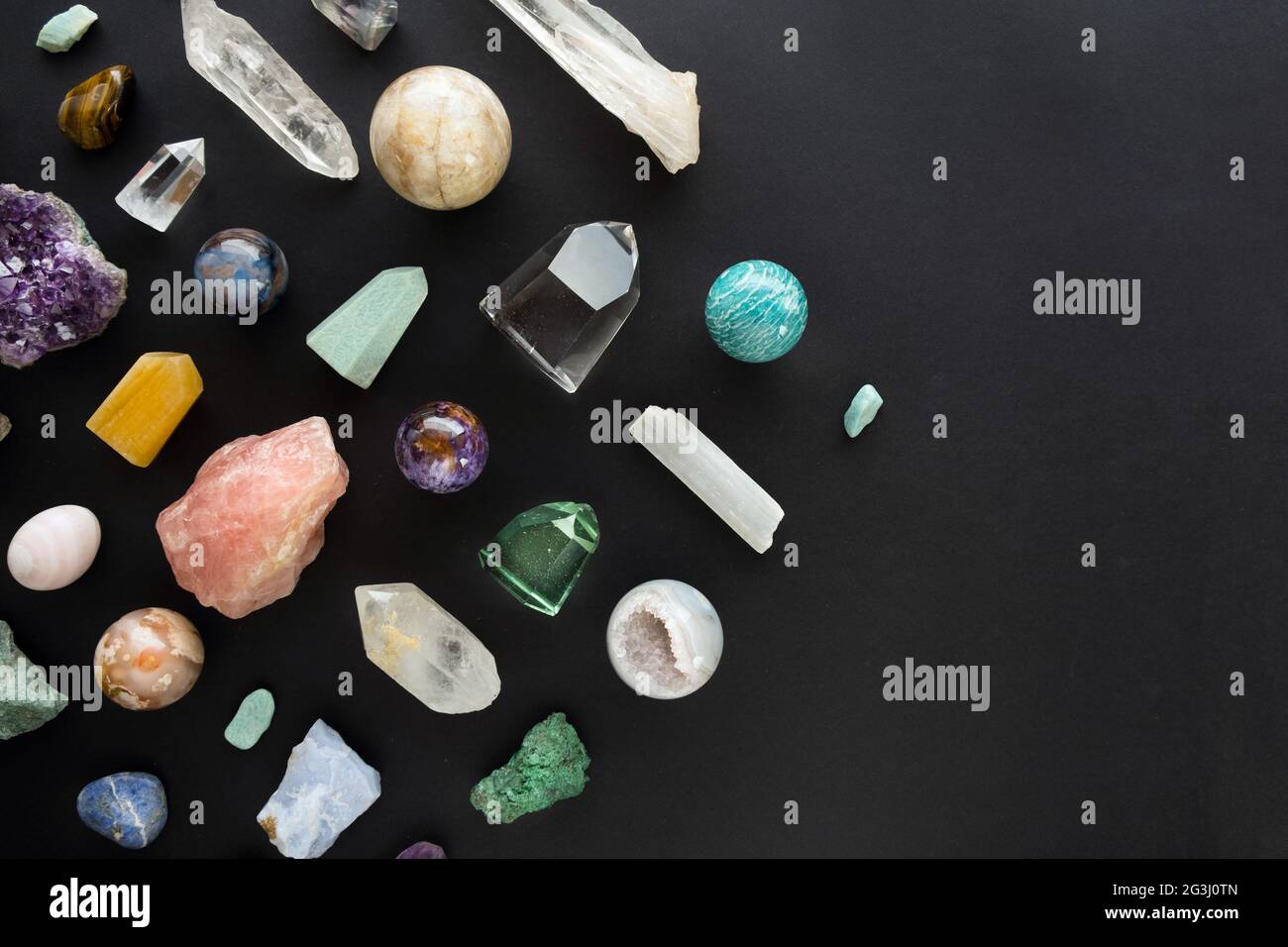 Flat lay of crystal stones on black background. Colorful gemstones and ...
