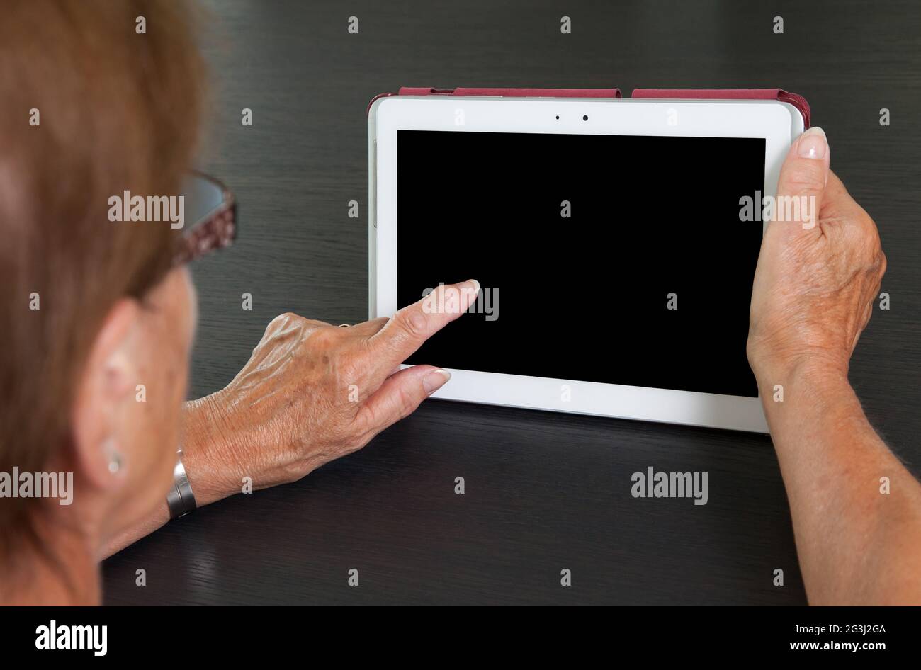 Senior lady relaxing and reading the screen of her tablet Stock Photo ...