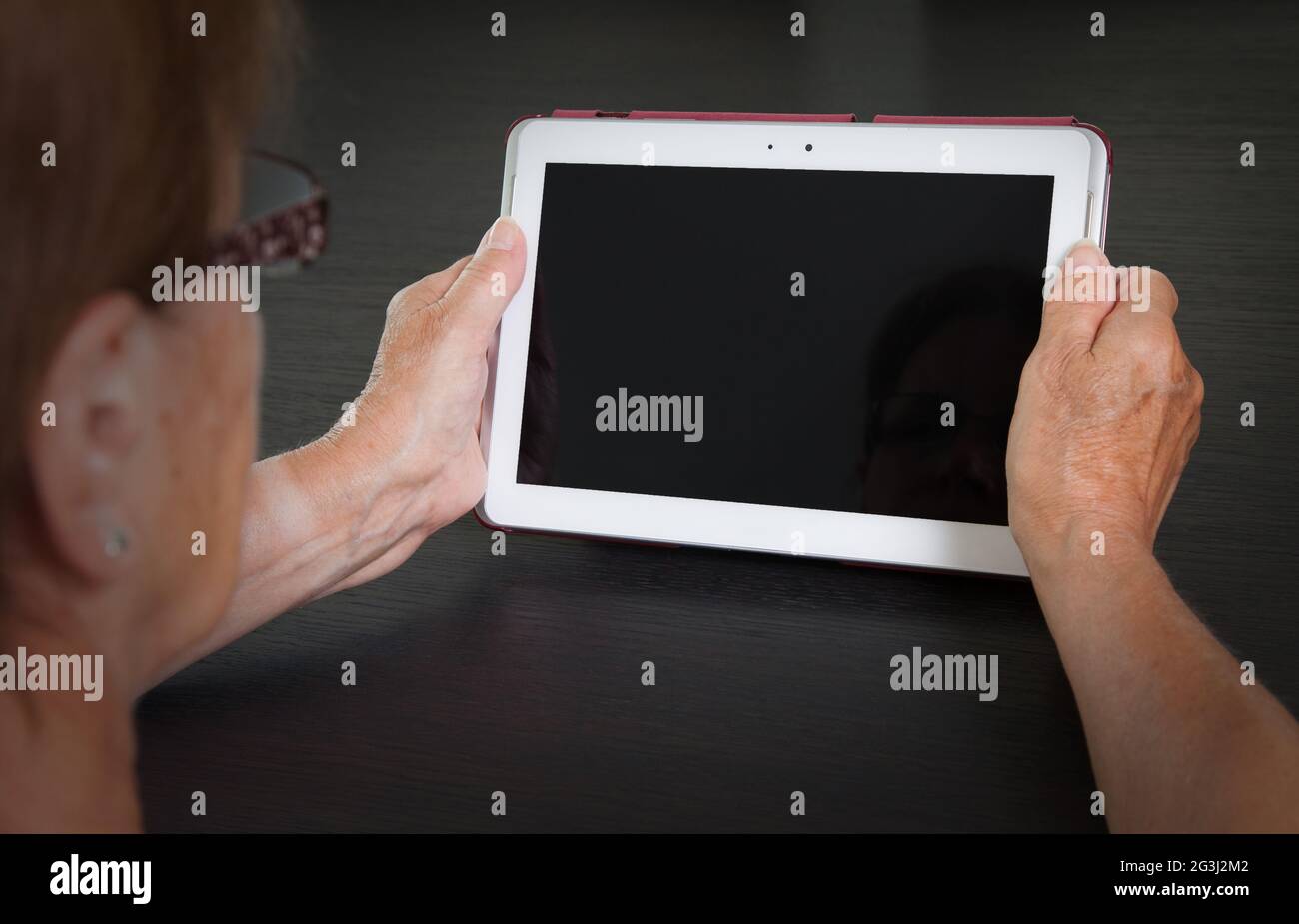 Senior lady relaxing and reading the screen of her tablet Stock Photo ...
