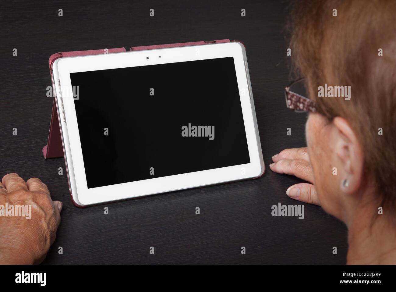 Senior lady relaxing and reading the screen of her tablet Stock Photo ...