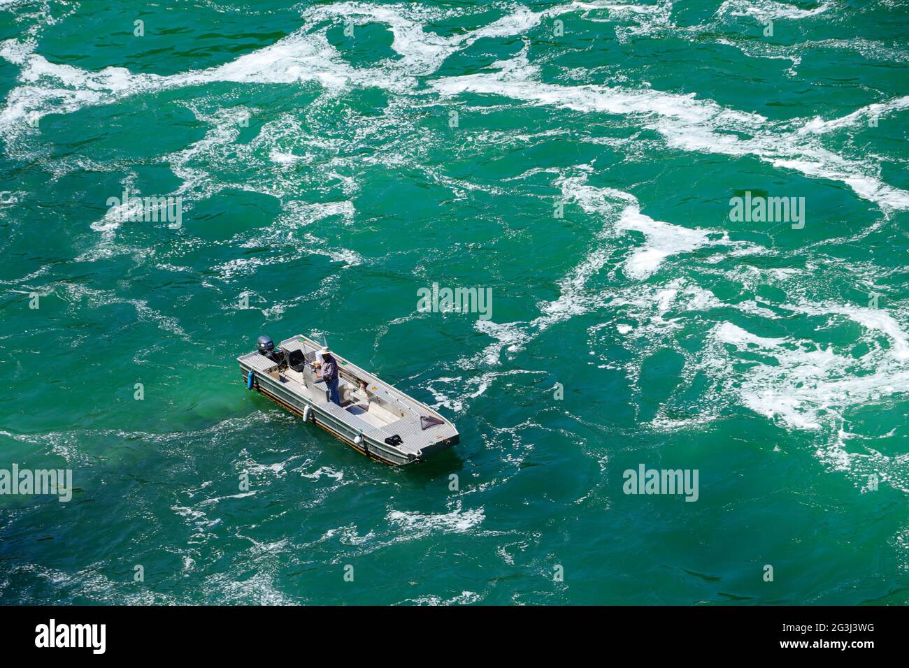 Fisher on boat in river with strong current Stock Photo - Alamy
