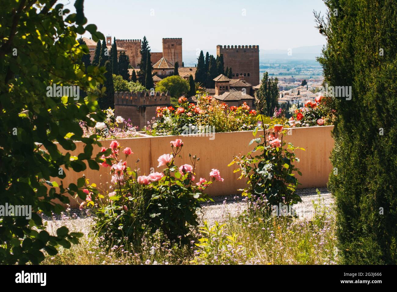 Peering at The Alhambra palace complex from behind ornate gardens of ...