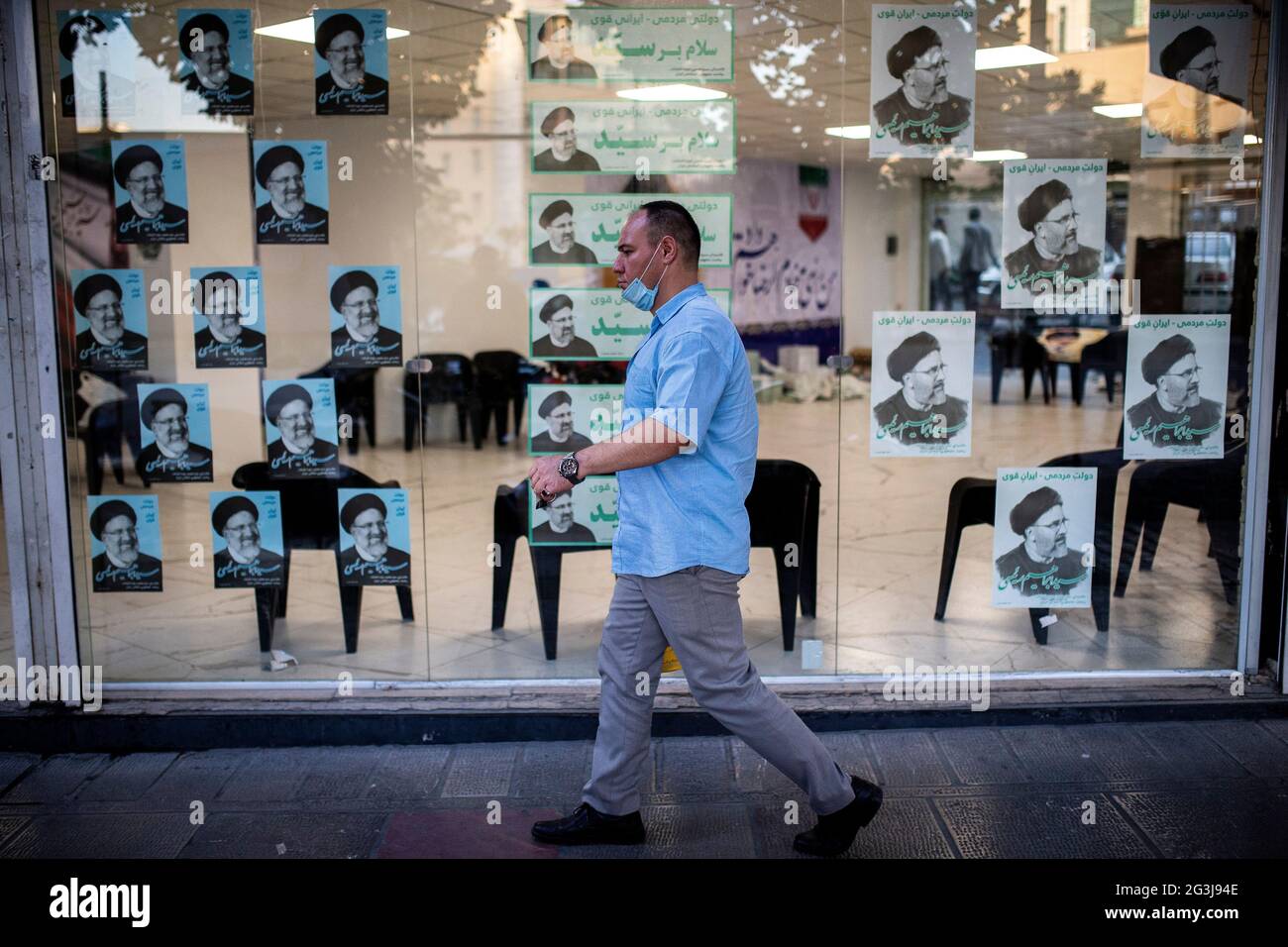 Tehran, Iran. 15th June, 2021. A man walks past presidential campaign ...