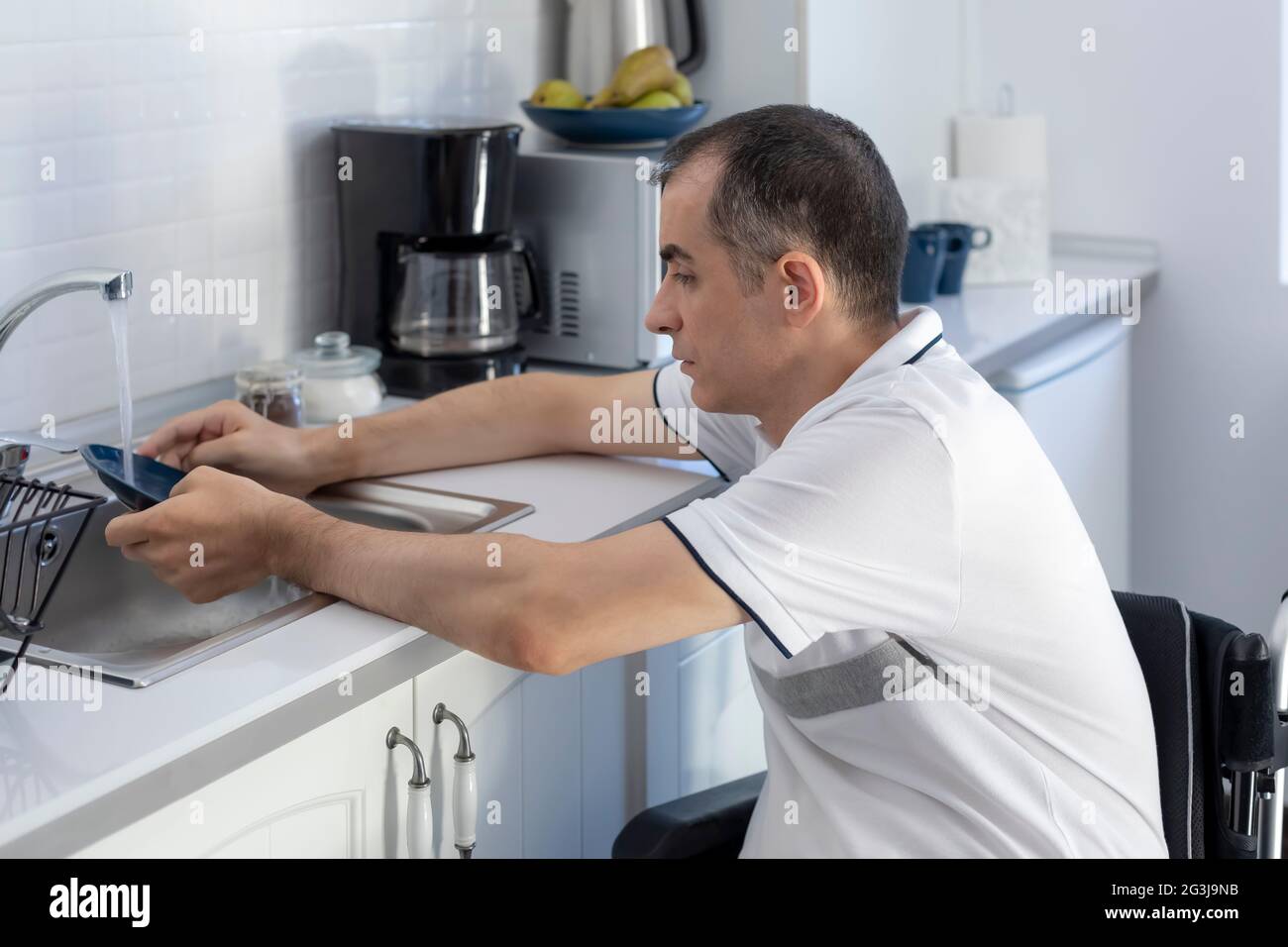 Young man Disabled Man On Wheelchair Washing Dishes. Smiling Young ...