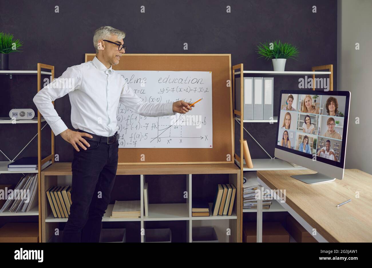 Teacher giving a virtual math lesson to a group of students via a video ...