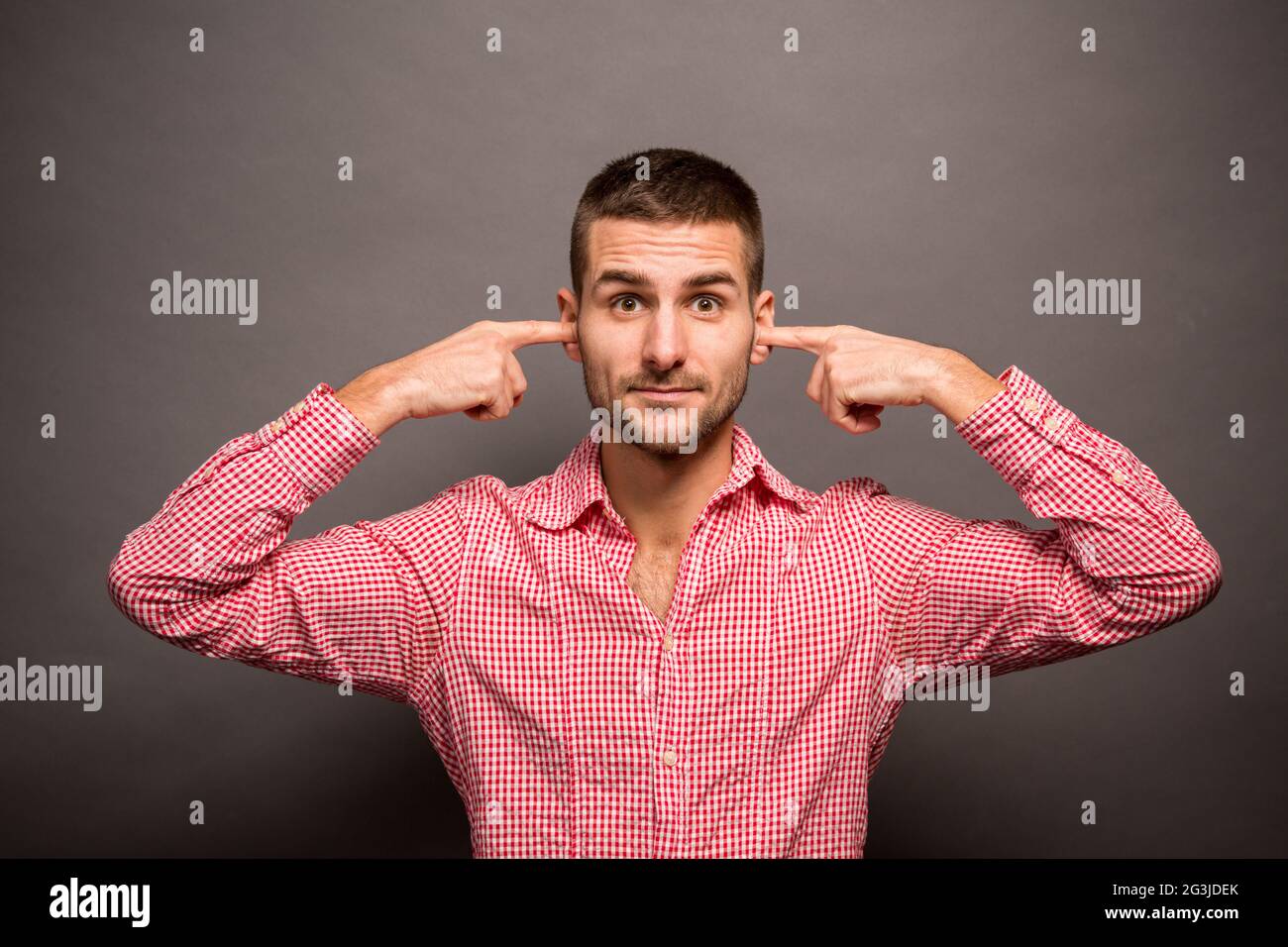 Man covering his ears Stock Photo - Alamy
