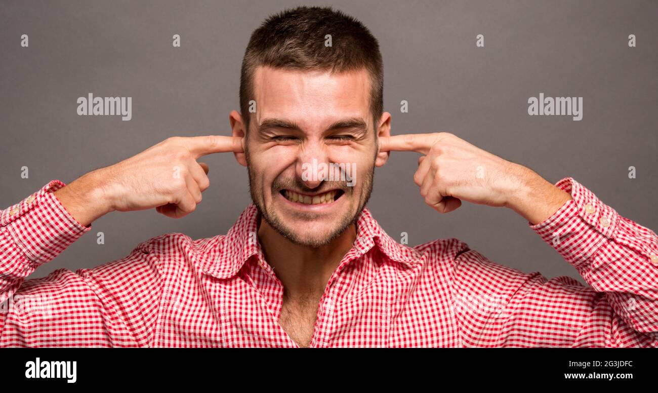 Man covering his ears Stock Photo - Alamy