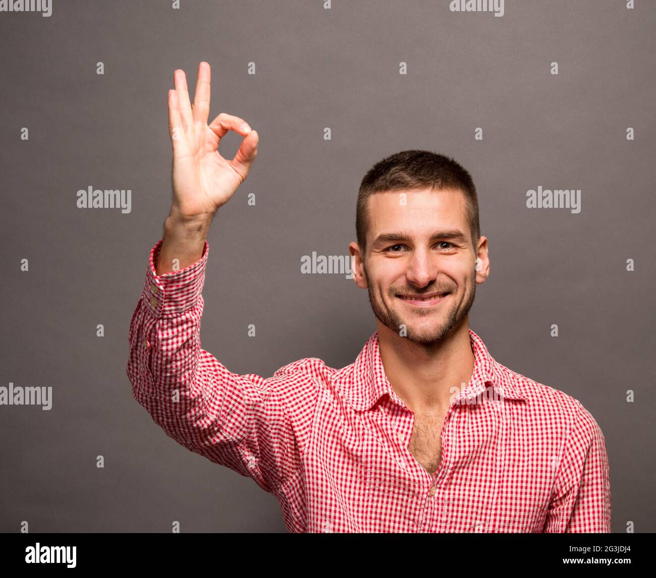 Handsome man showing okay sign Stock Photo - Alamy