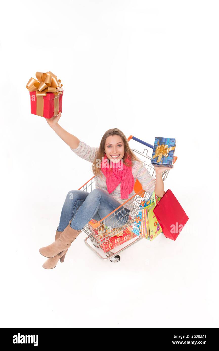 Happy woman in shopping cart with presents Stock Photo - Alamy