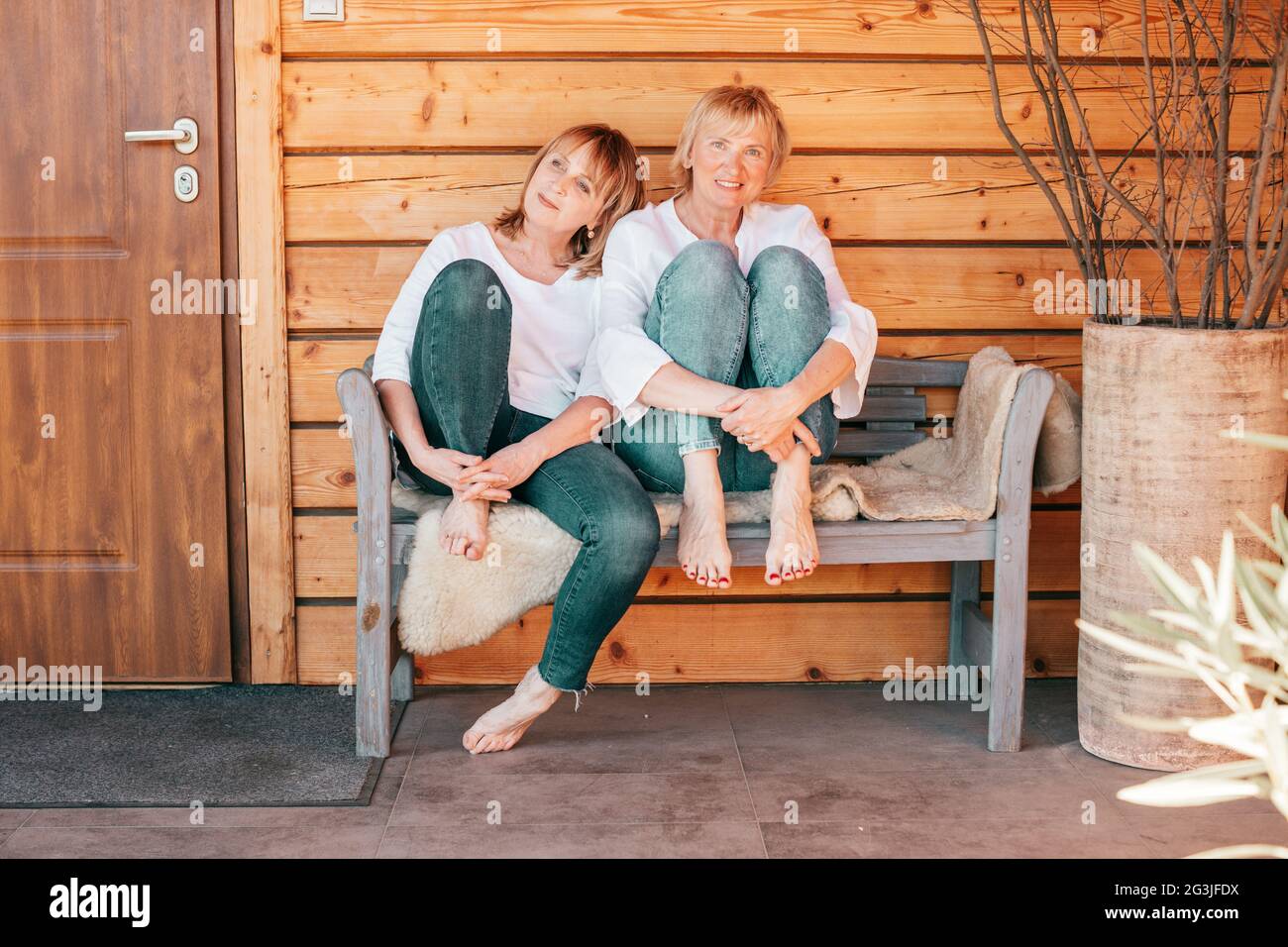 Portrait of two old female friends on wooden background spending free ...