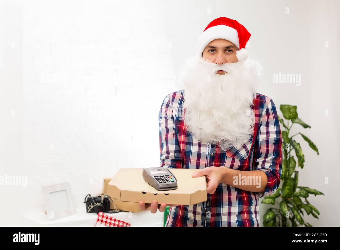 Santa Claus holding a pizza box and pos terminal on white background ...