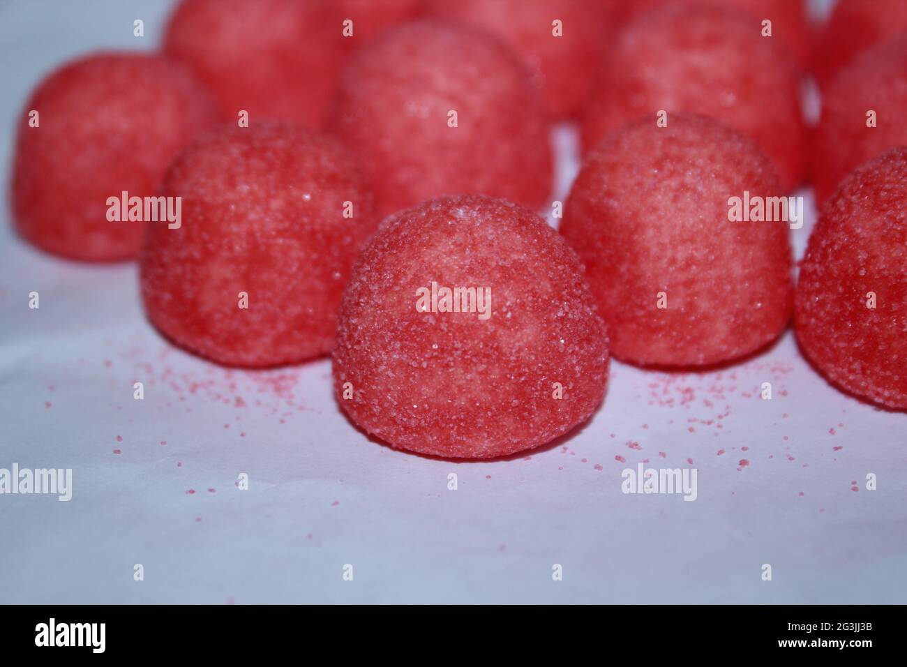 Red strawberry candies on white background Stock Photo - Alamy
