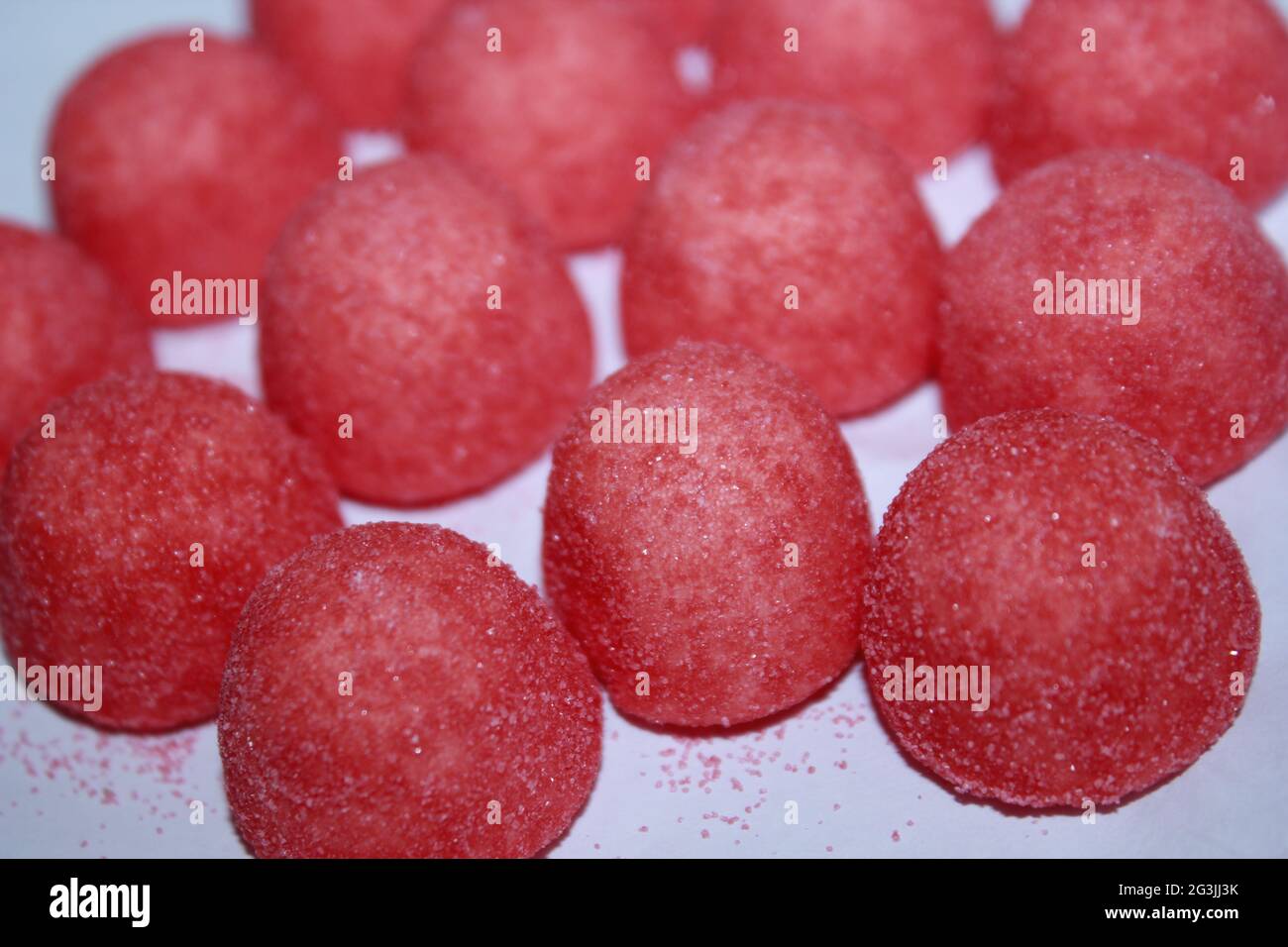 Red strawberry candies on white background Stock Photo - Alamy