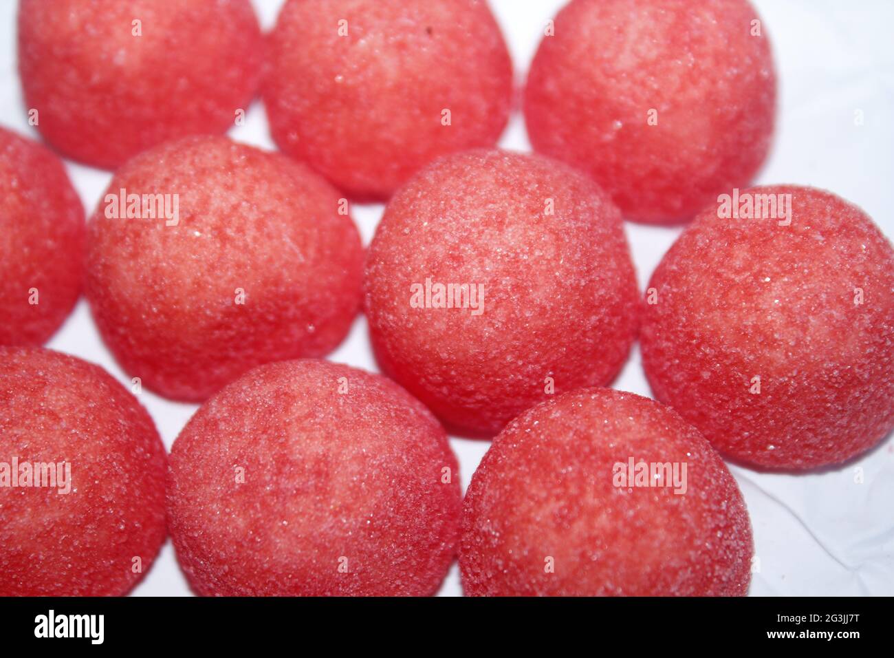 Red strawberry candies on white background Stock Photo - Alamy
