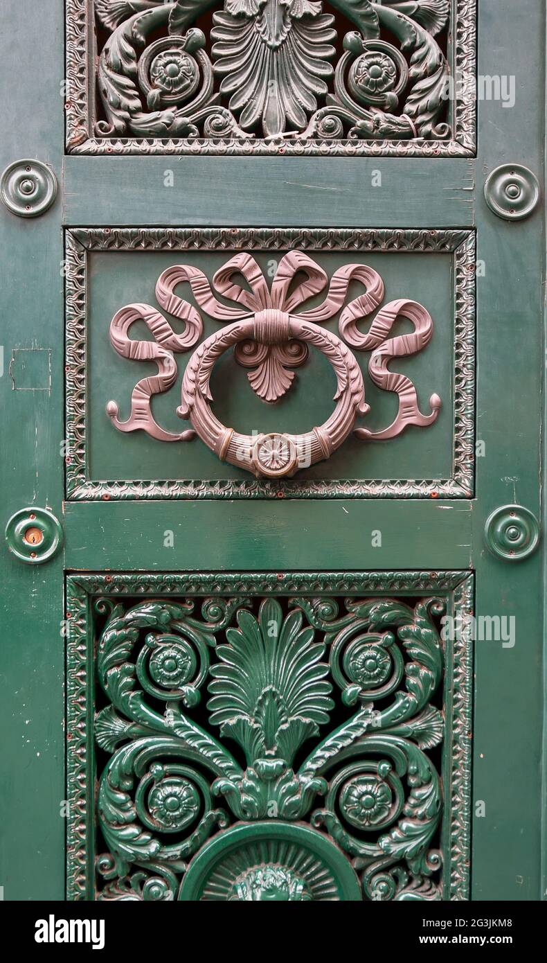 Close-up of the green door of an ancient building with a bow-shaped ...