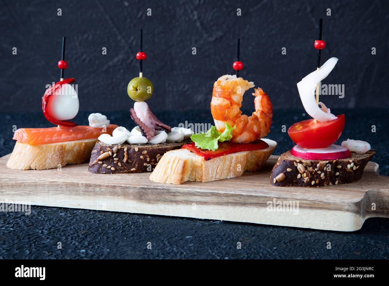 Traditional Spanish tapas - set of four pieces with squid, octopus ...