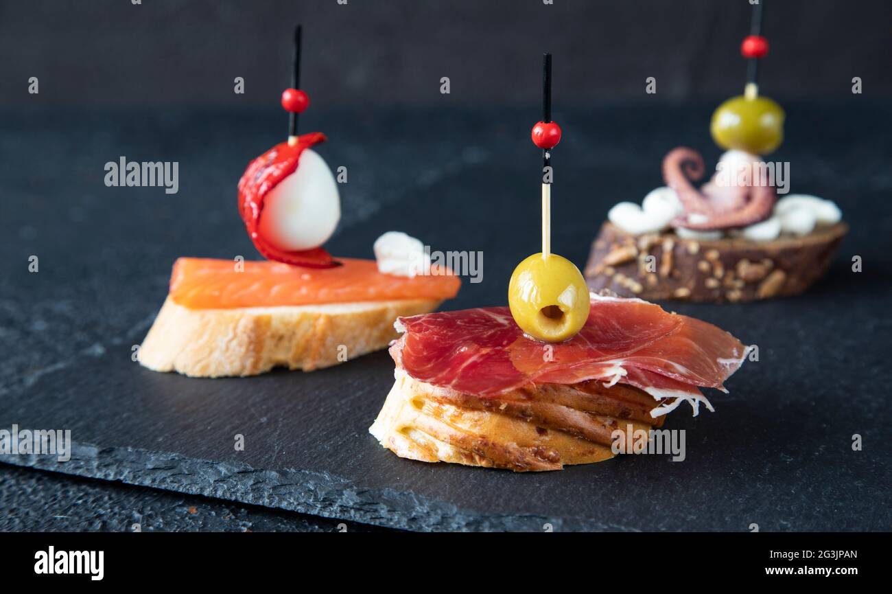 Traditional Spanish tapas - with jamon and green olive on a bruschetta ...