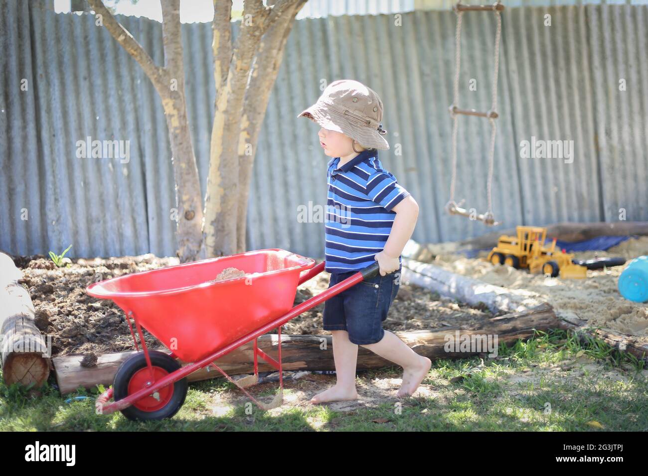 Kid riding a small construction wheelbarrow in the playground Stock ...