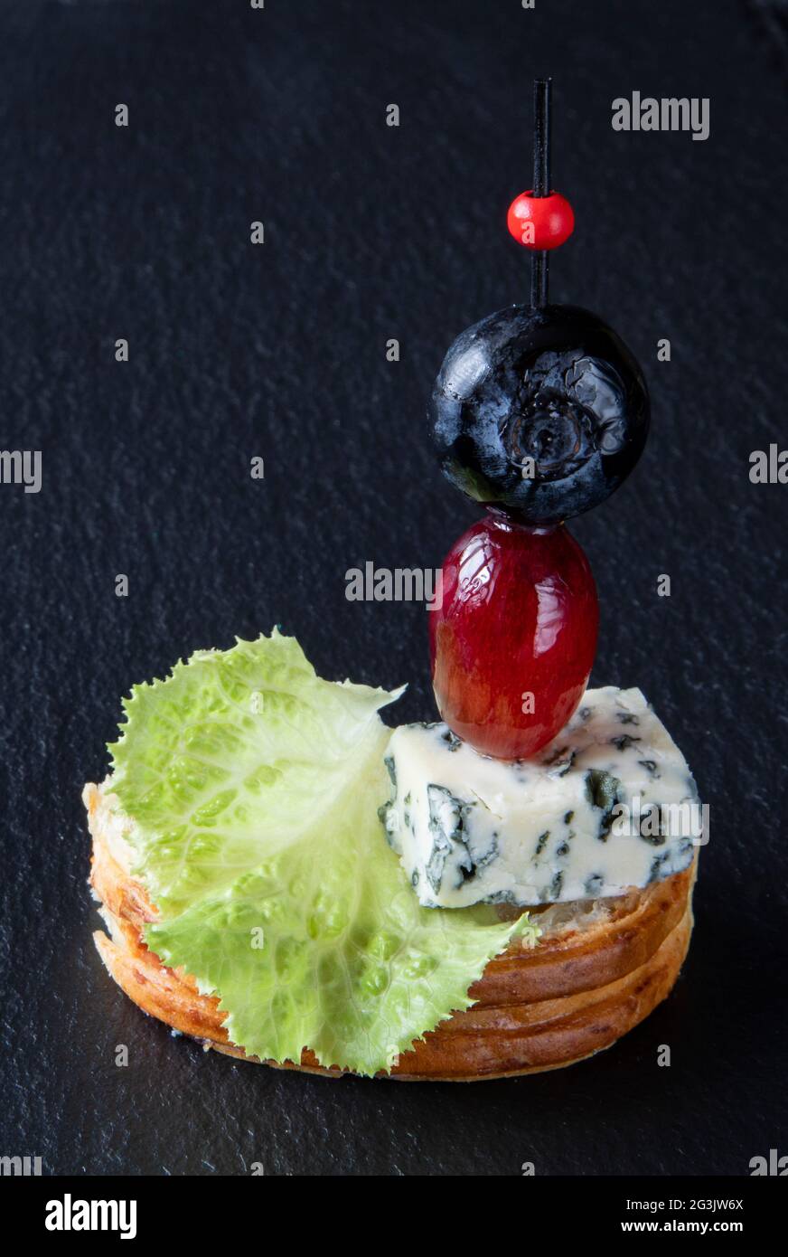 Traditional Spanish tapas sandwich with fresh grape and blueberry with ...