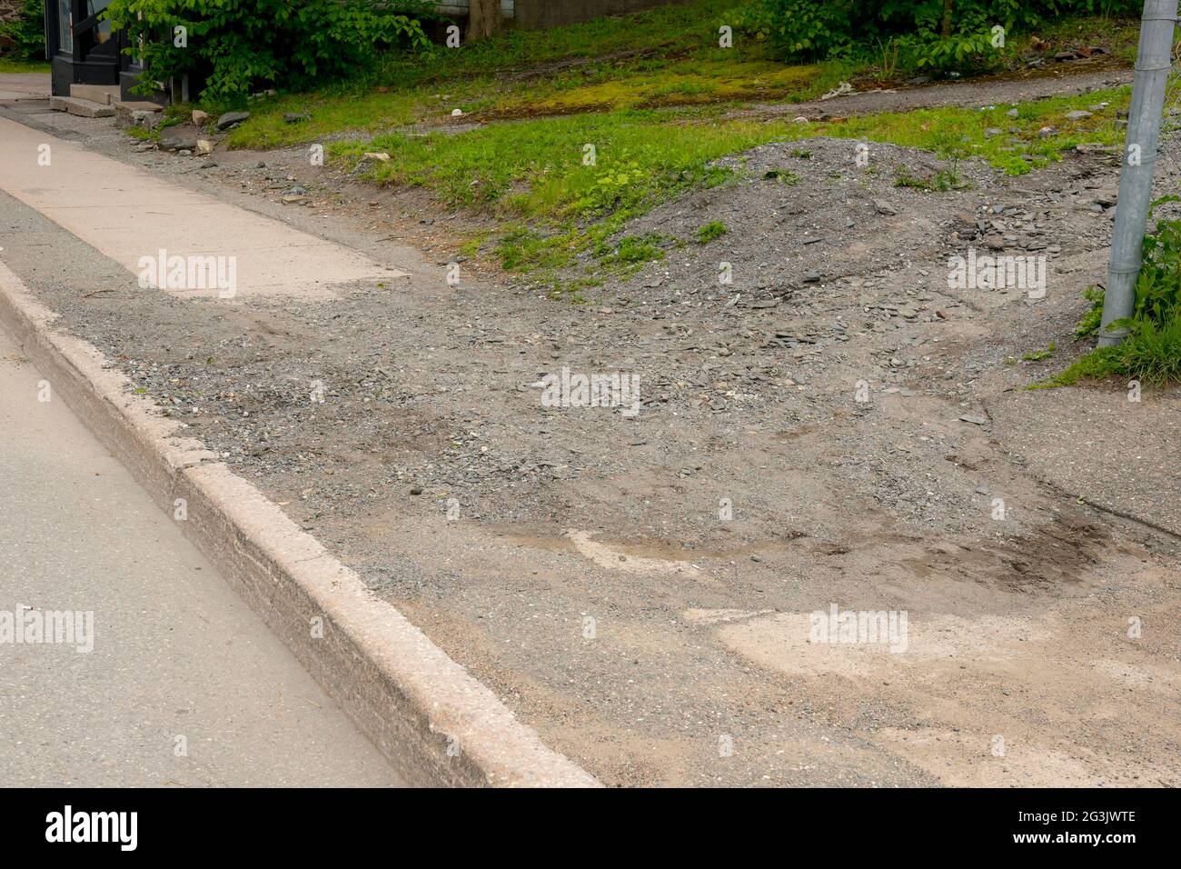 Small landslide across a sidewalk. The landslide is made of rock and ...