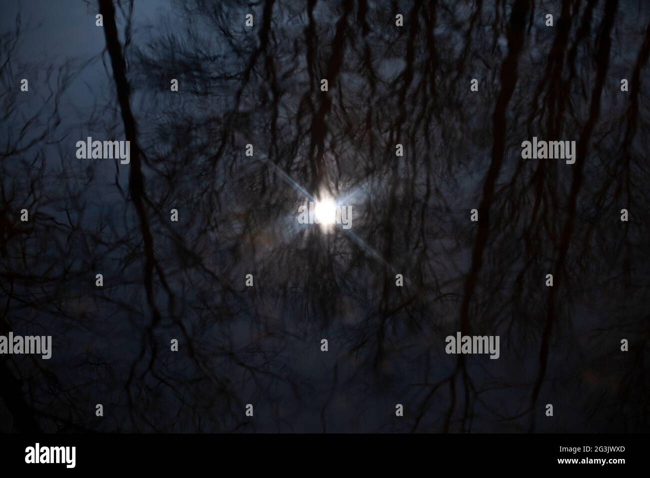 Reflection of the sun in the water. Bright sun in dark water. Summer ...