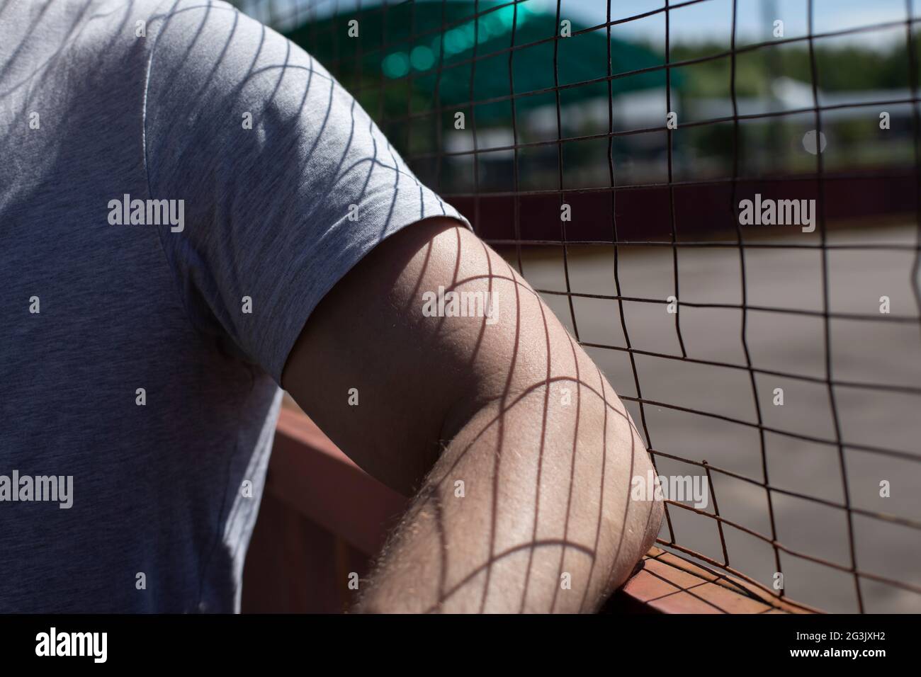Mesh shadow on the elbow. Shoulder of a man. Man's hand in the shadow ...