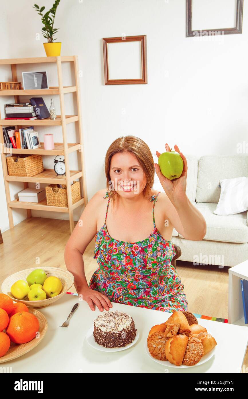 Fat woman sitting at table home Stock Photo - Alamy