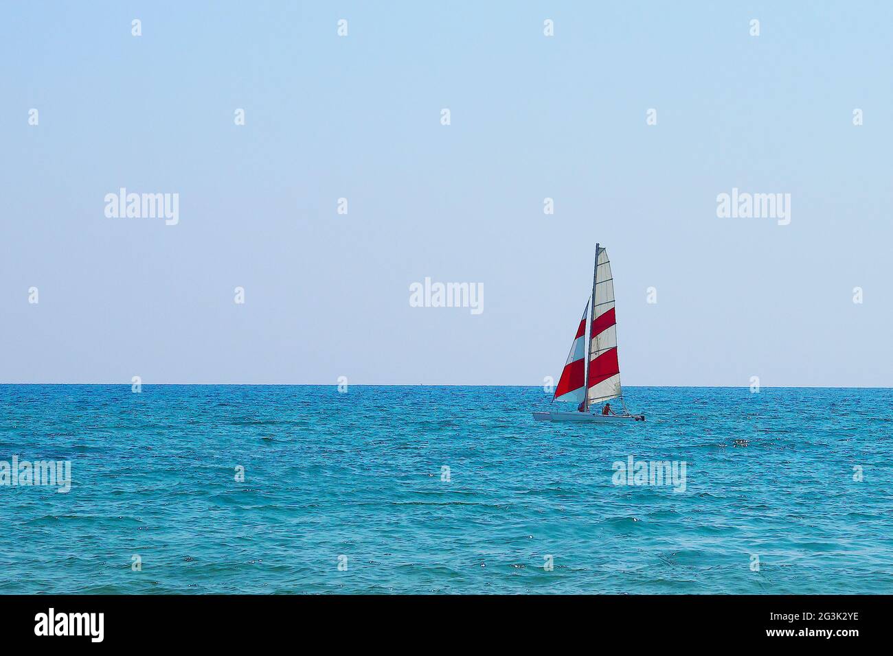 lone beachable catamaran sailing on the sea Stock Photo - Alamy