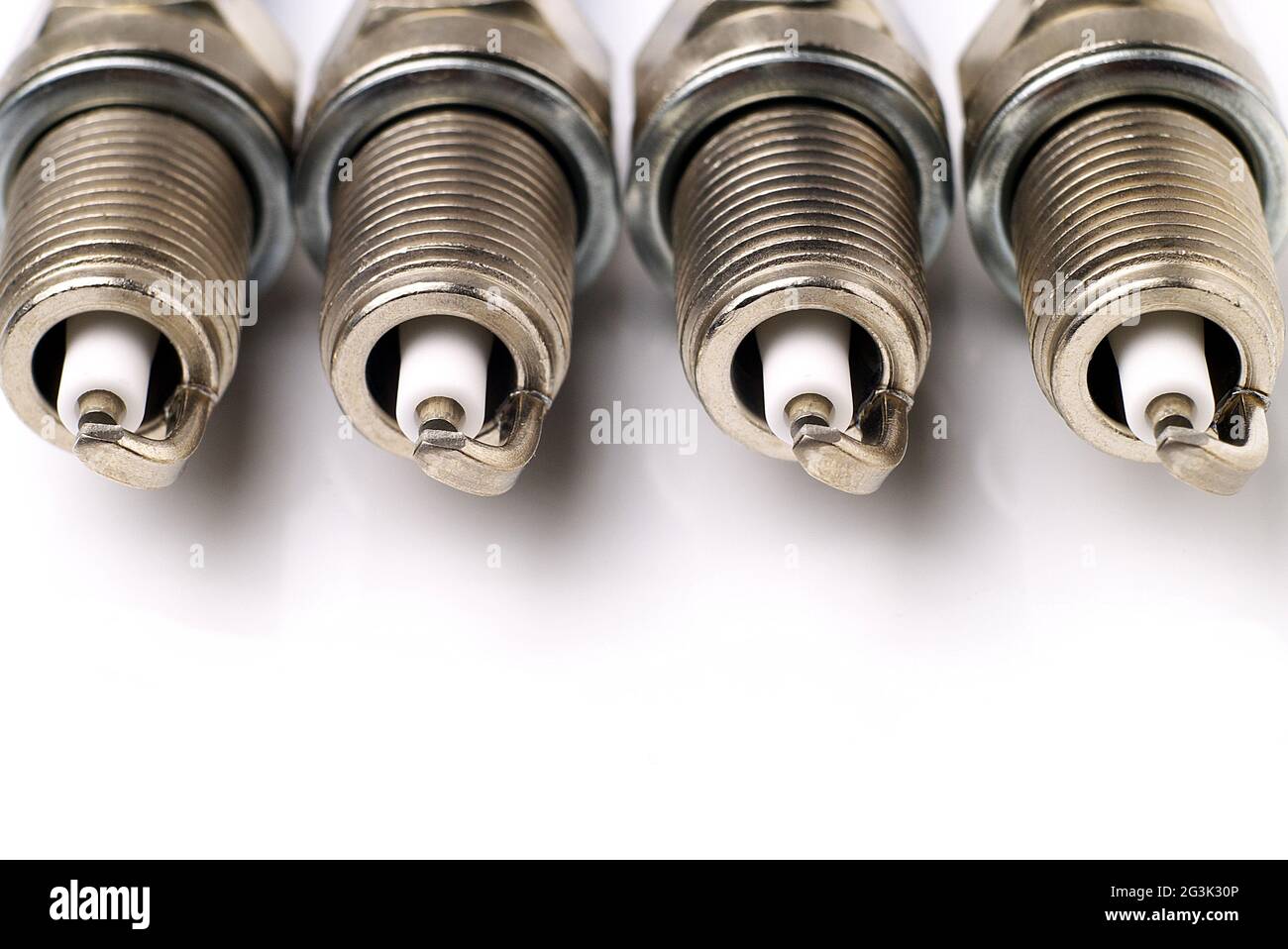 four brand new unused spark plugs on white background, suitable for ...