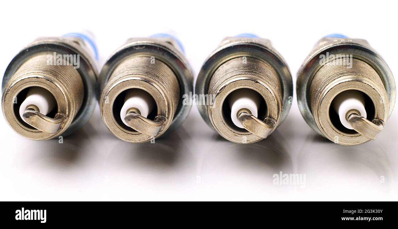 four brand new unused spark plugs on white background, suitable for ...