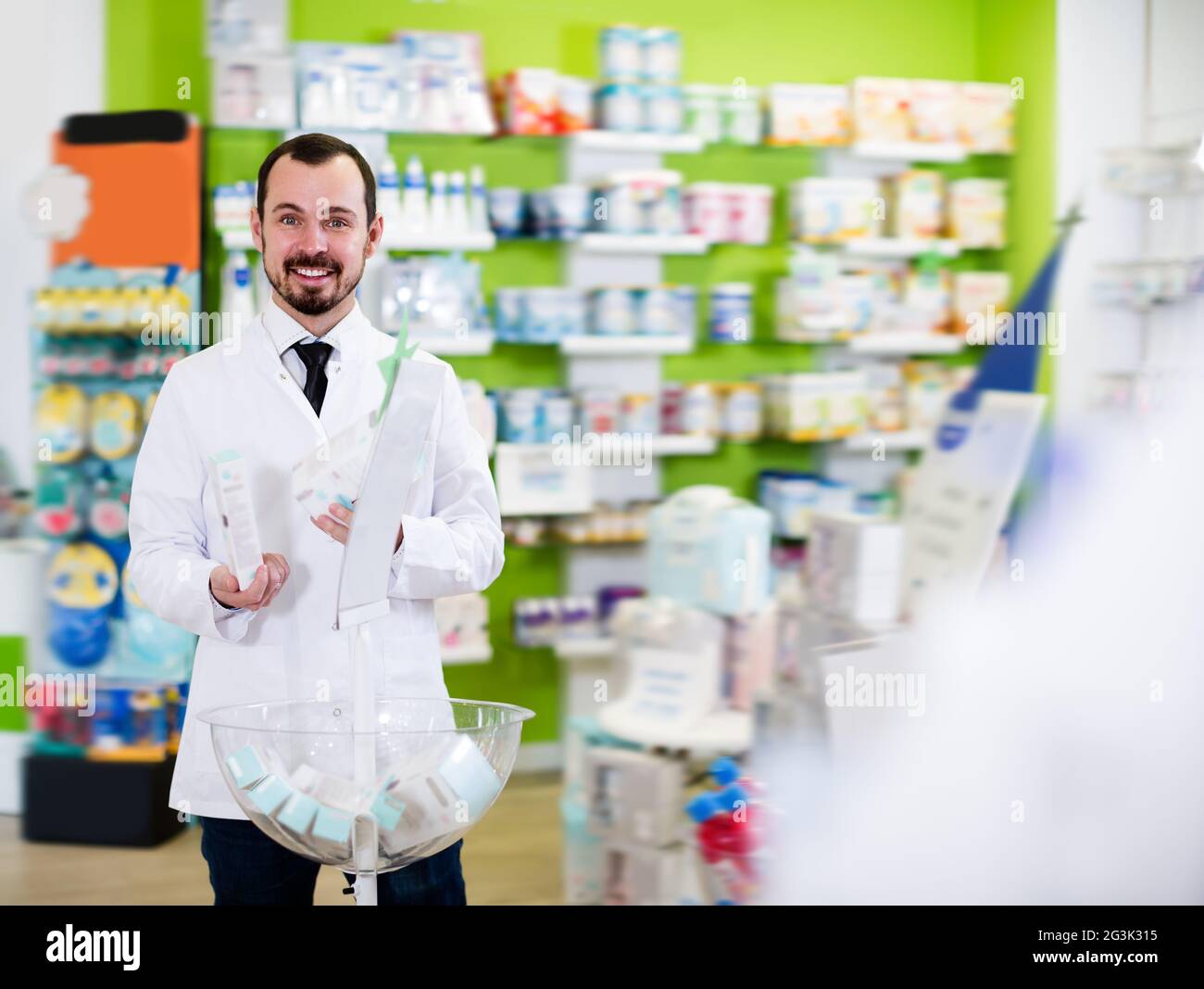 Positive male pharmacist suggesting useful drug Stock Photo - Alamy
