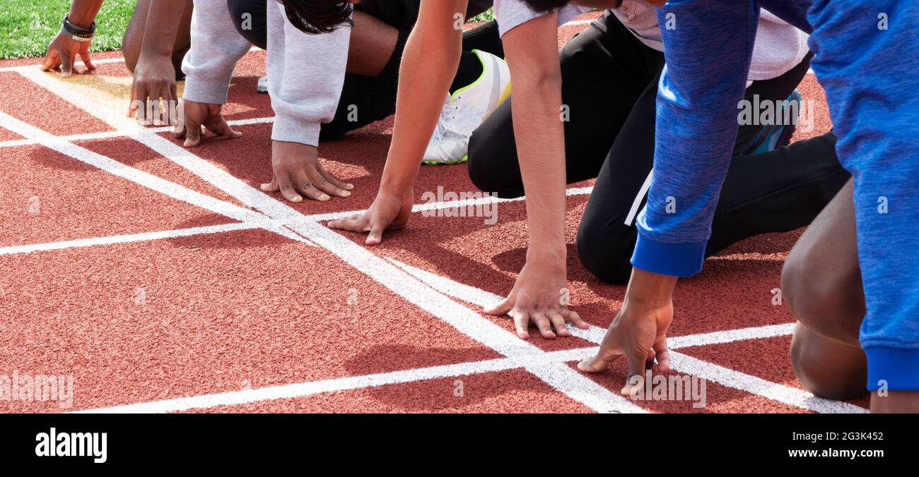 Five high school boys on their mark at the start line ready to sprint ...