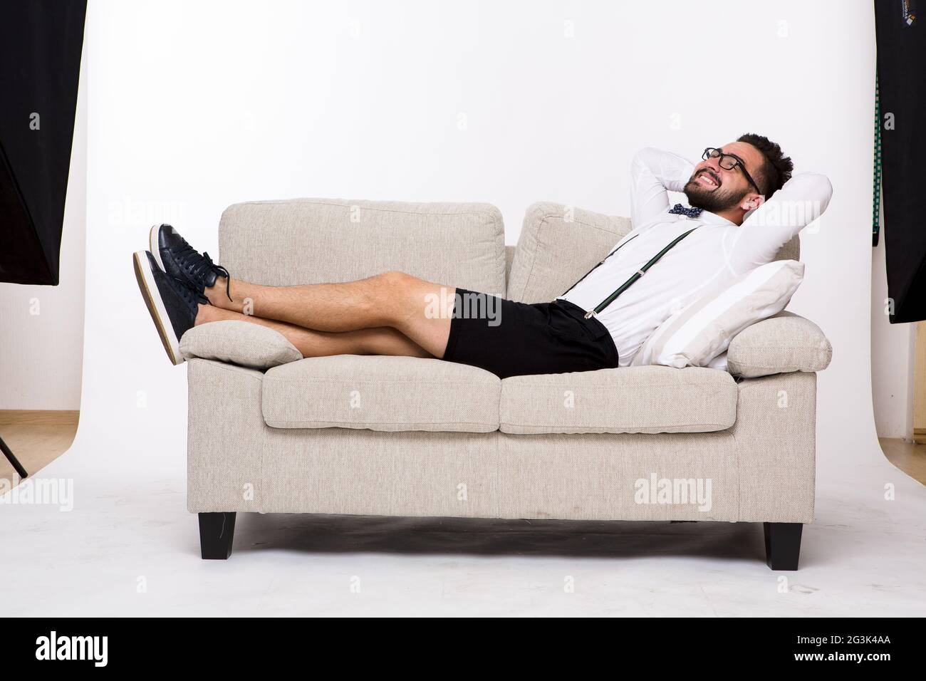 Smiling handsome man lying on couch Stock Photo - Alamy