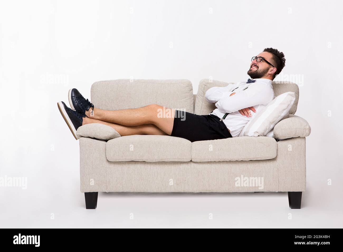 Smiling handsome man lying on couch Stock Photo - Alamy