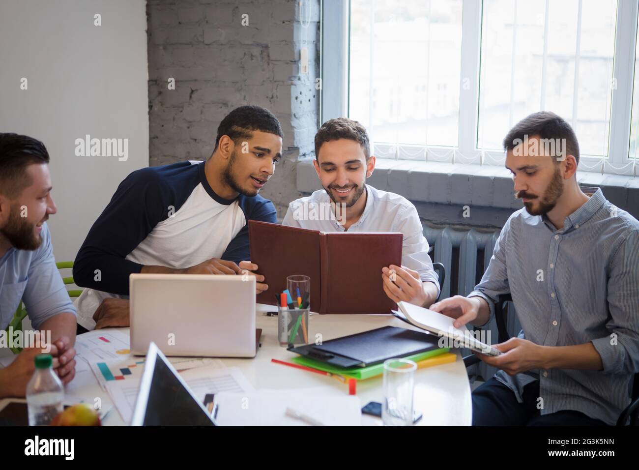 Group people sitting round table hi-res stock photography and images ...