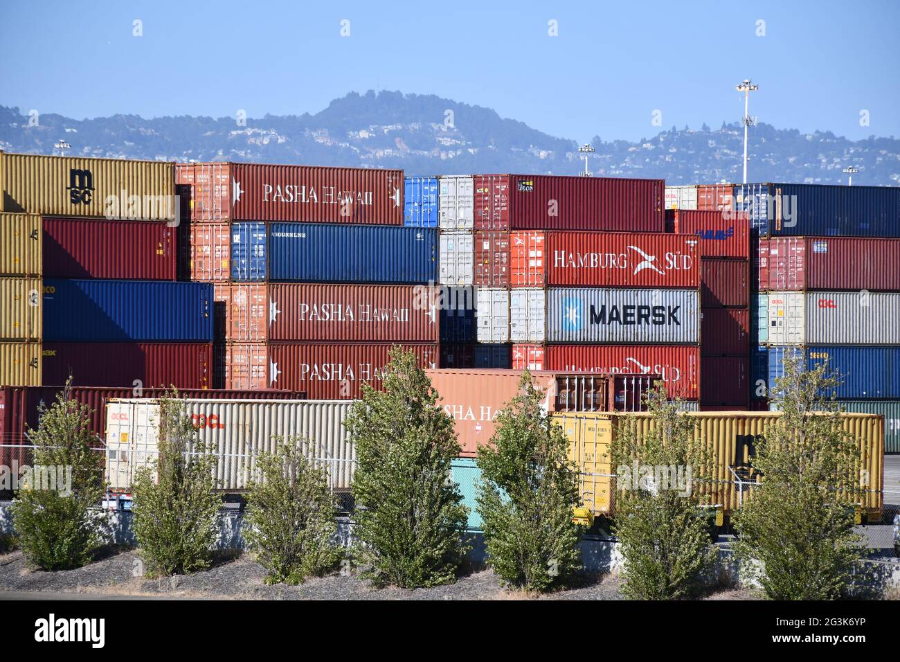 Shipping containers are loaded onto ships at the Port of Oakland ...