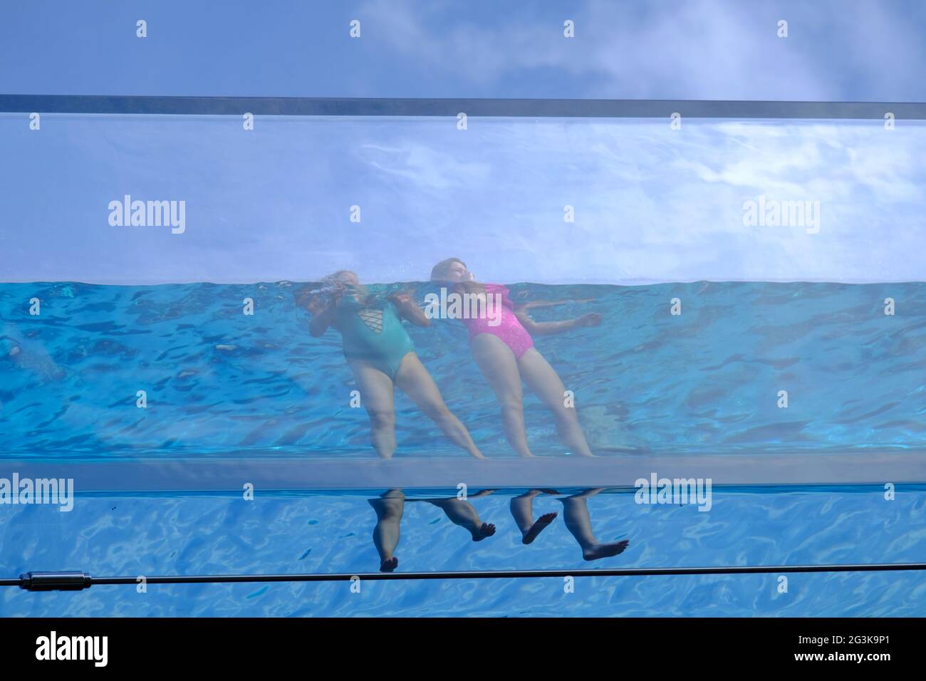 London, UK. Two swimmers at the Embassy Gardens Sky Pool come to the ...