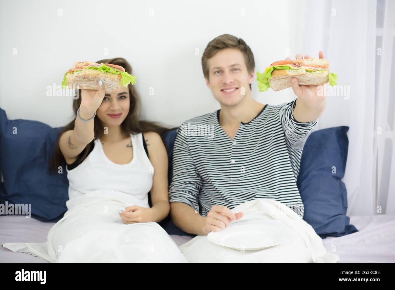 Couple eating in bed Stock Photo - Alamy