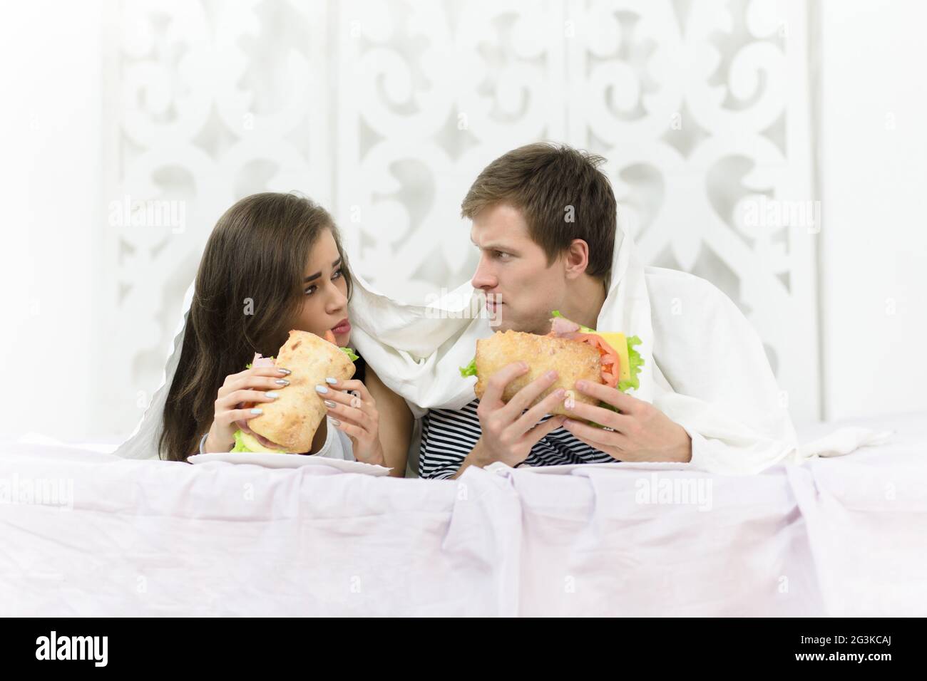 Couple eating in bed Stock Photo - Alamy