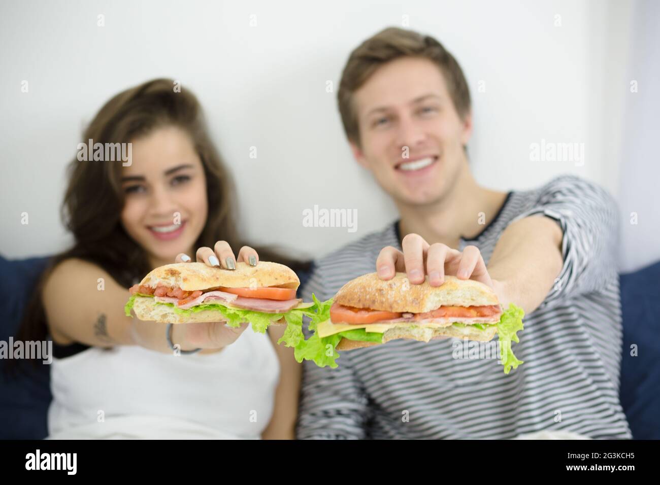 Couple eating in bed Stock Photo - Alamy