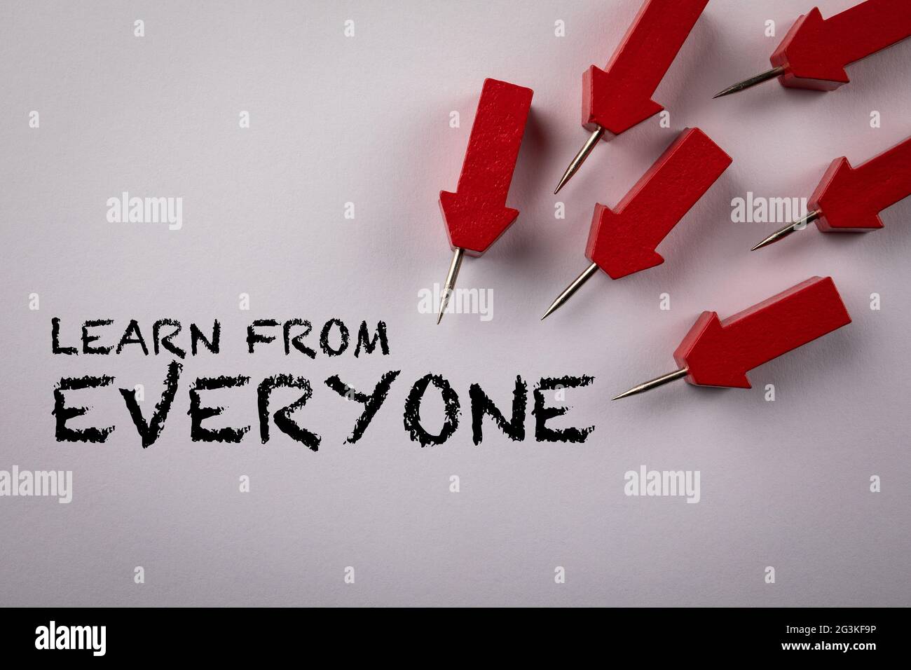 Learn From Everyone. Text and red arrows on a white sheet of paper ...