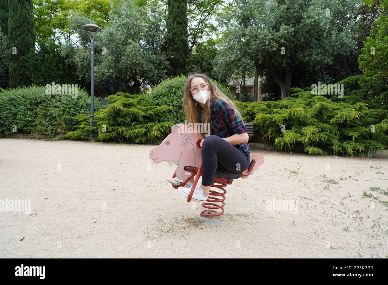 Caucasian female with a medical face mask in a playground Stock Photo ...